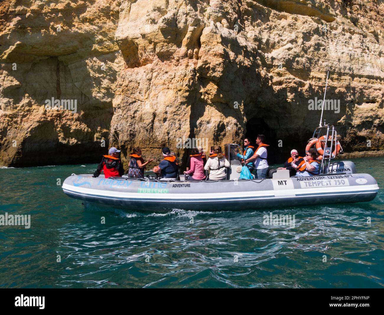 Tourists aboard a semi-rigid inflatable boat boat exploring the caves ...