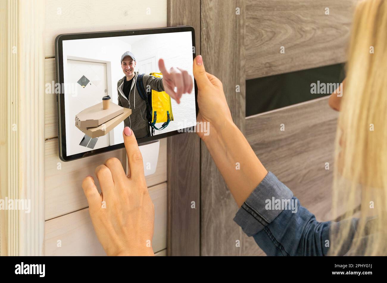 Delivery man ringing door bell on cctv secure camera system on tablet ...