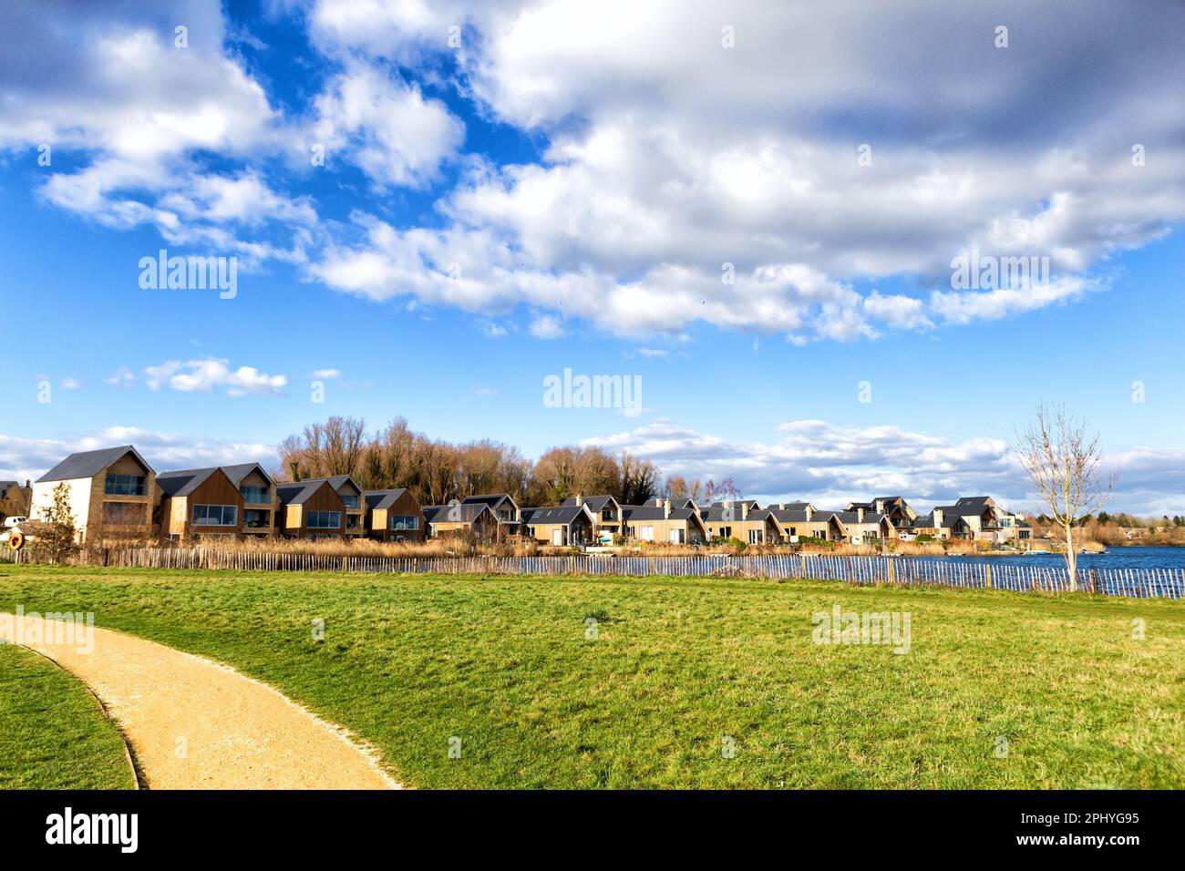 Modern houses and a park around a lake Stock Photo - Alamy