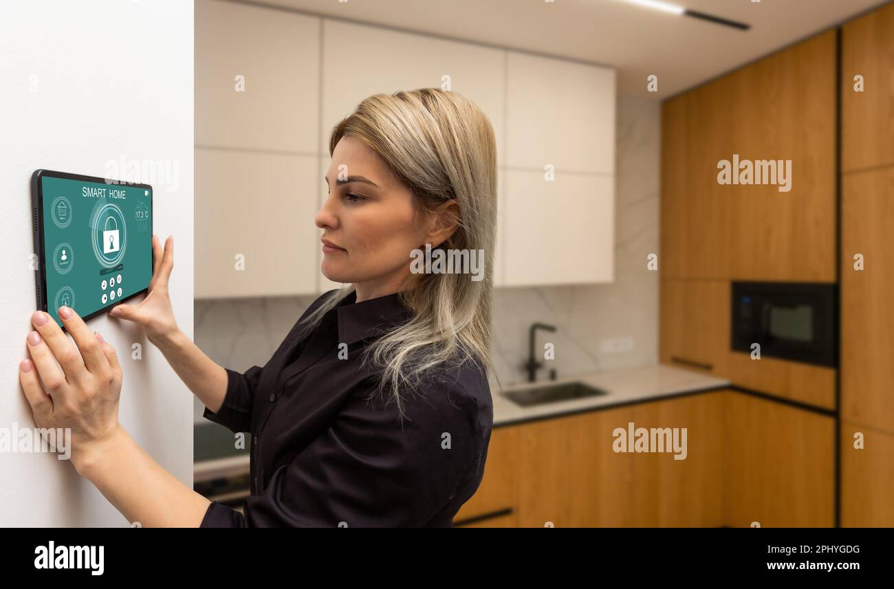 Side view pleasant young woman using smart home system or activating ...