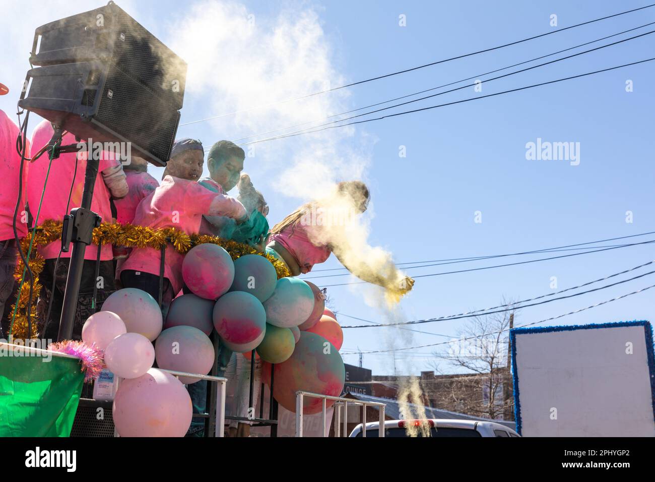 A group of diverse people spreading color powder on each other at the ...