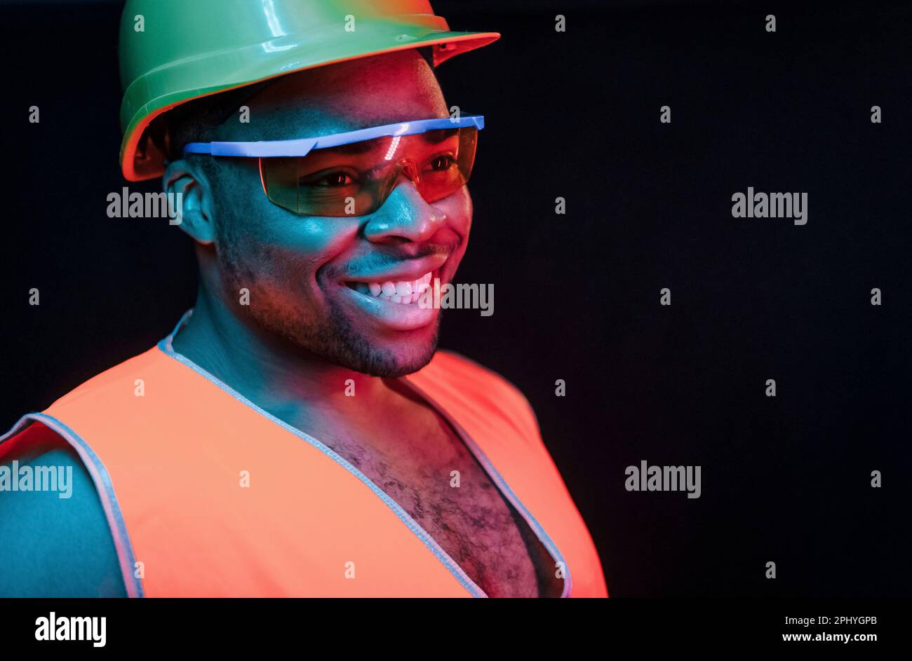 Construction worker in uniform and hard hat. Futuristic neon lighting ...