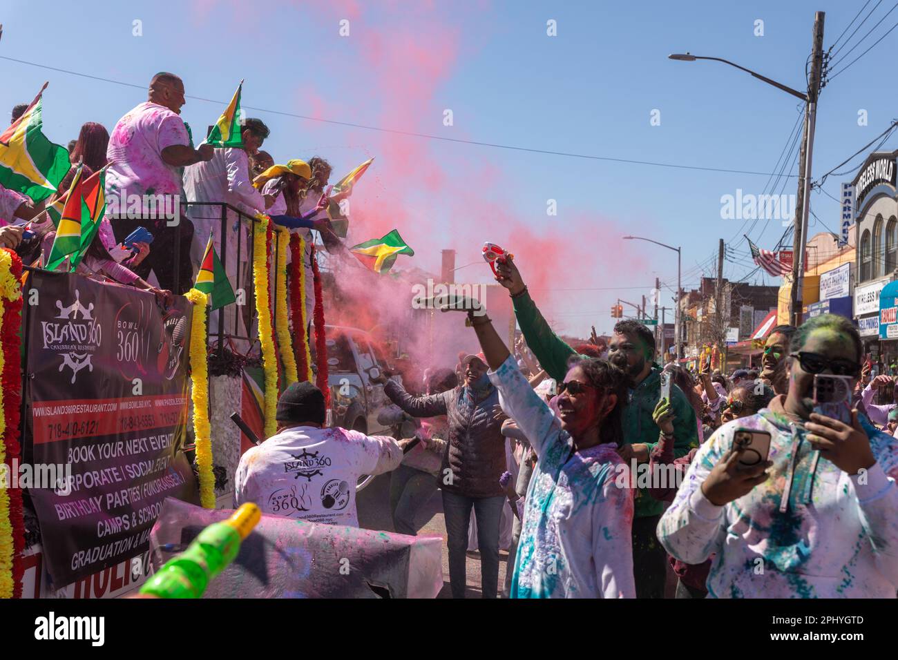 A group of diverse people spreading color powder on each other at the ...