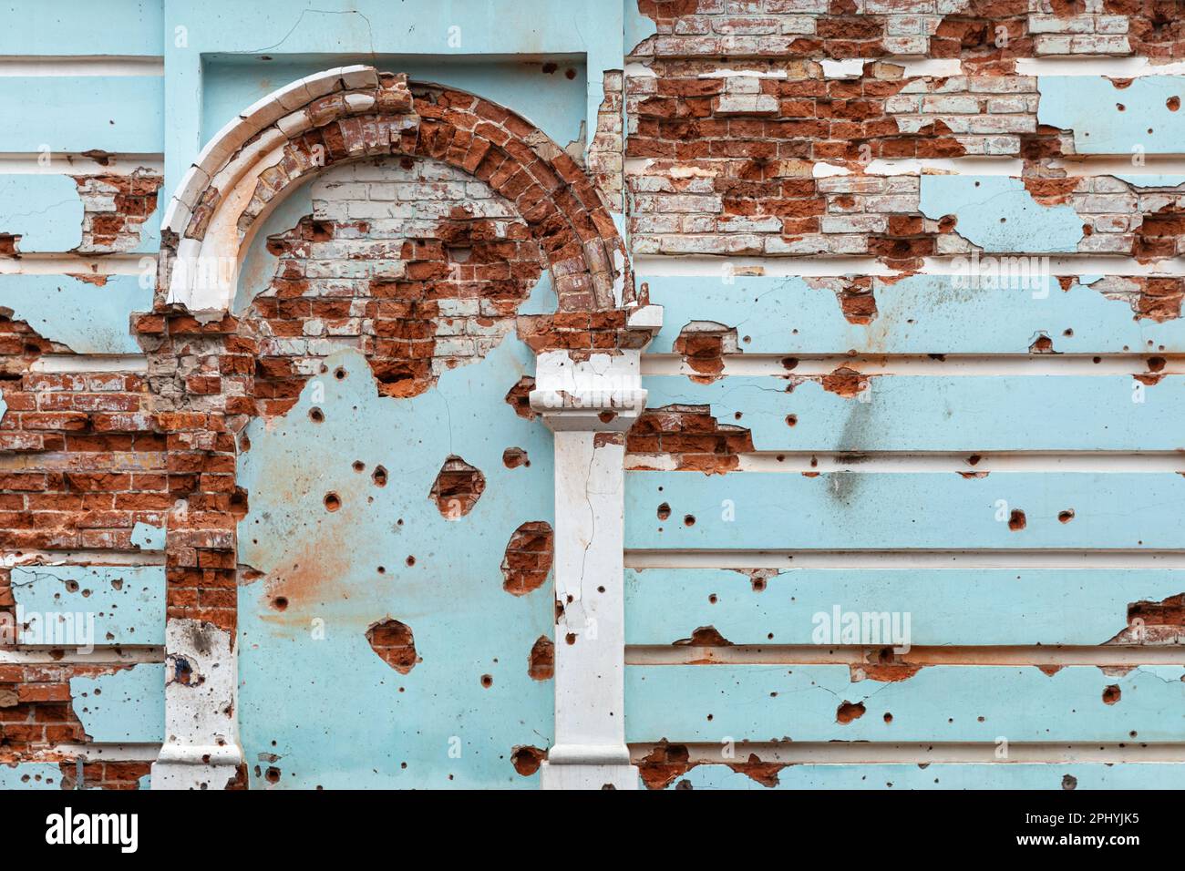 Wall of a townhouse showing blast damage and bullet holes. Izyum in the ...