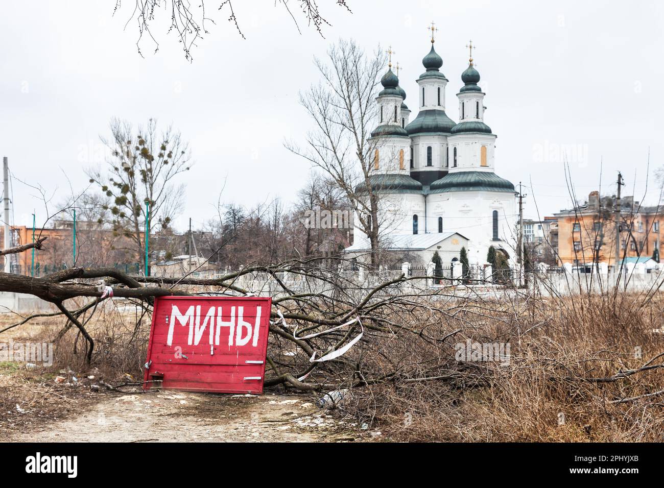 A warning sign "Mines" can be seen on a wooden tablet near a fallen ...