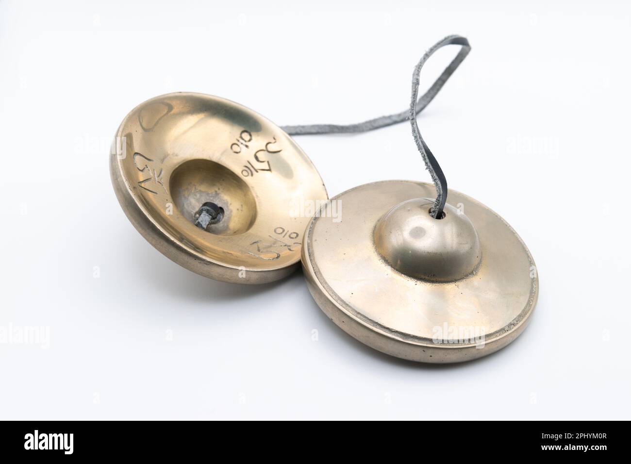 Tibetan Buddhist tingsha (tibetan cymbals) with leather strap isolated ...