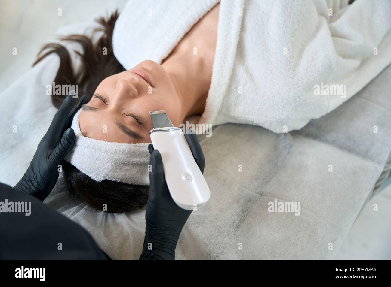 Dermatologist holding instrument and cleaning skin, working in salon ...