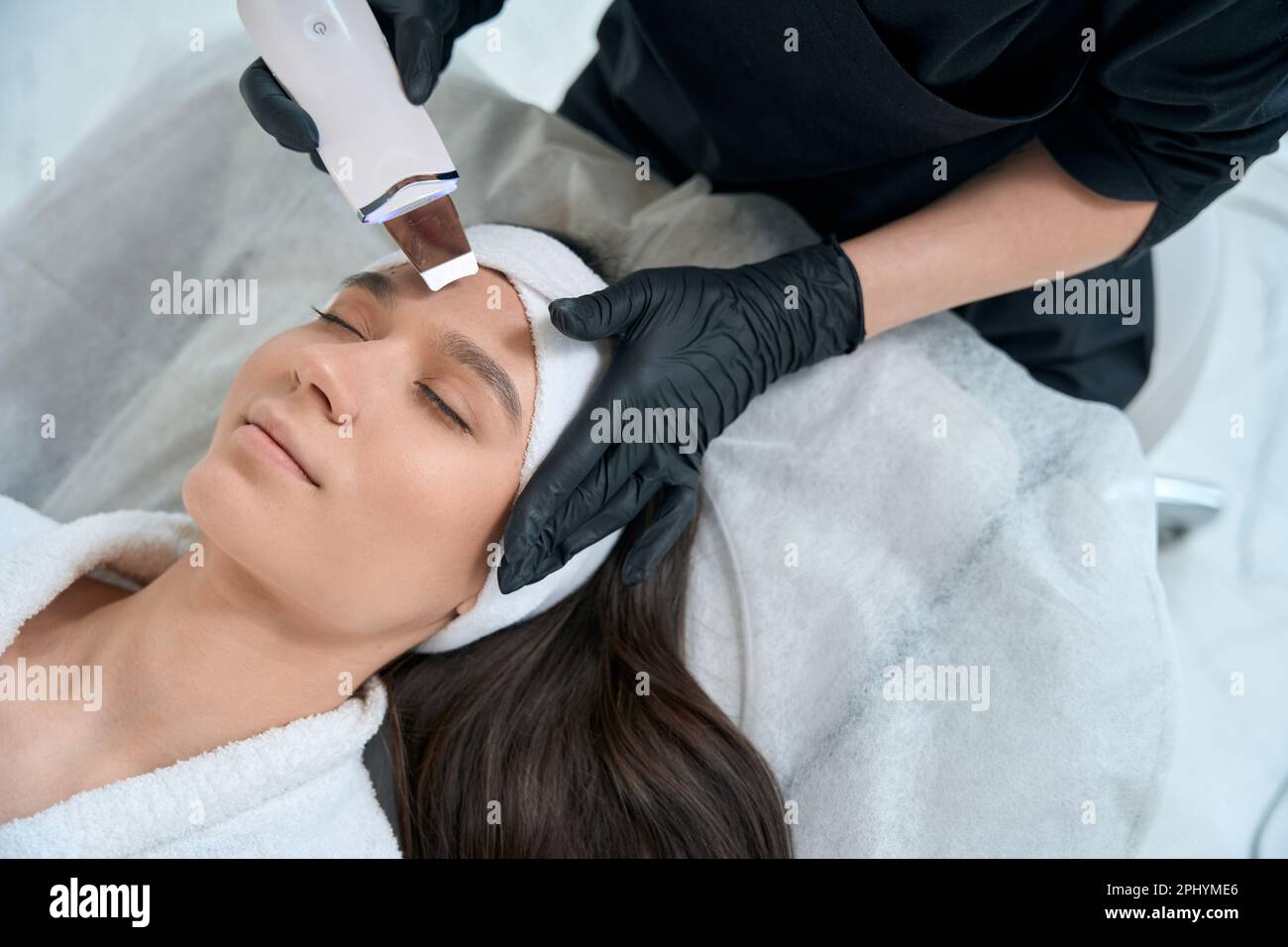 Doctor holding instrument and cleaning skin, working in salon Stock ...