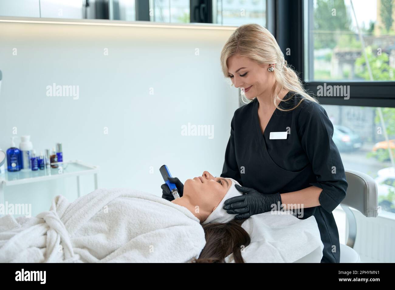 Beautiful doctor holding device and doing skin resurfacing procedure ...