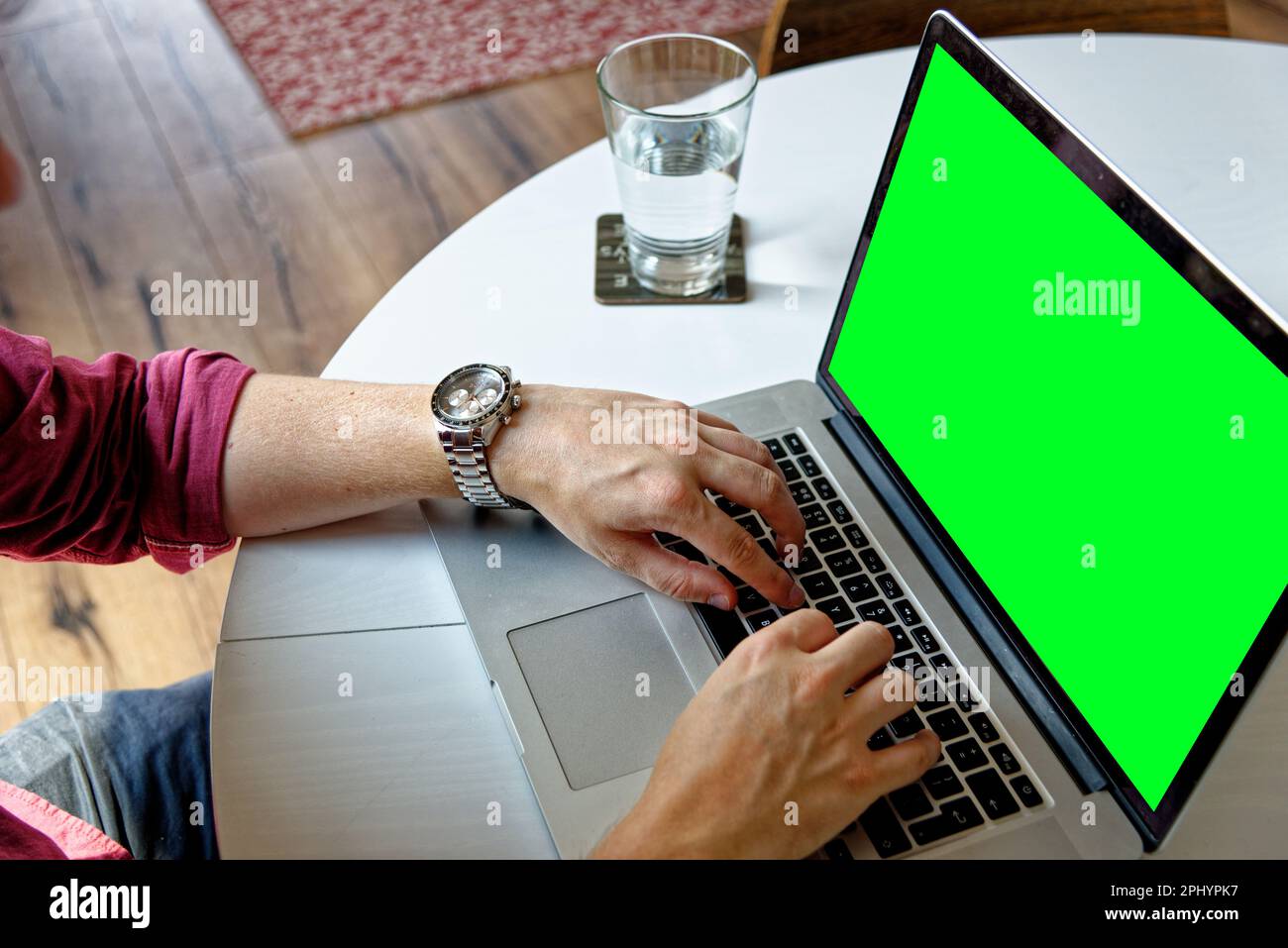 Young professional man using a laptop with a green screen - wearing a ...