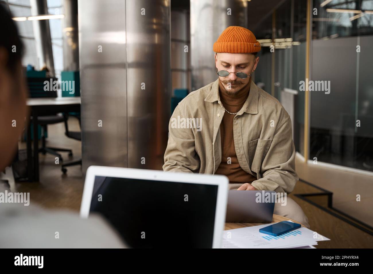 Two employees using their laptops in company office Stock Photo - Alamy
