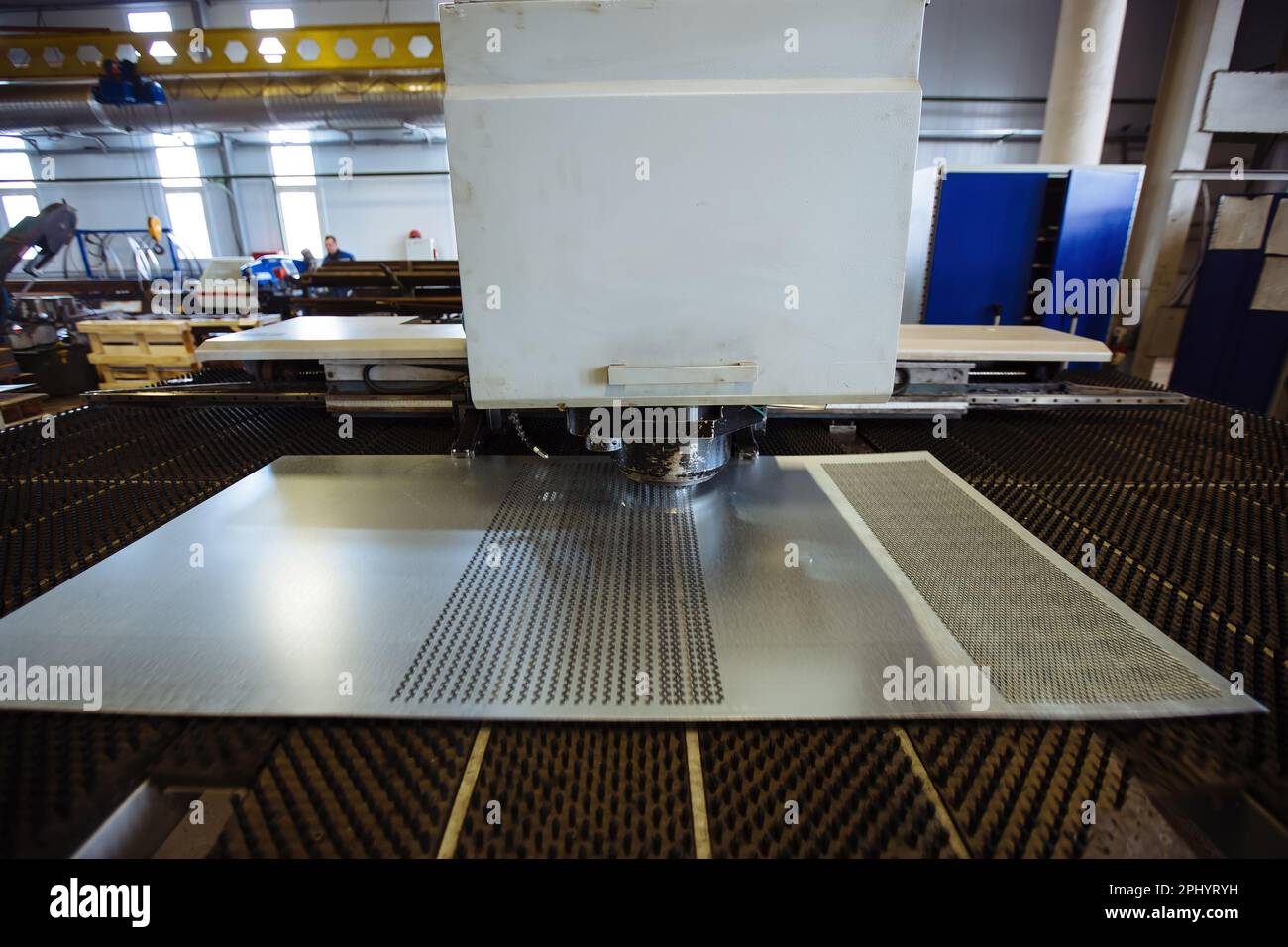 CNC punching and nibbling machine and perforated steel sheet, close up ...