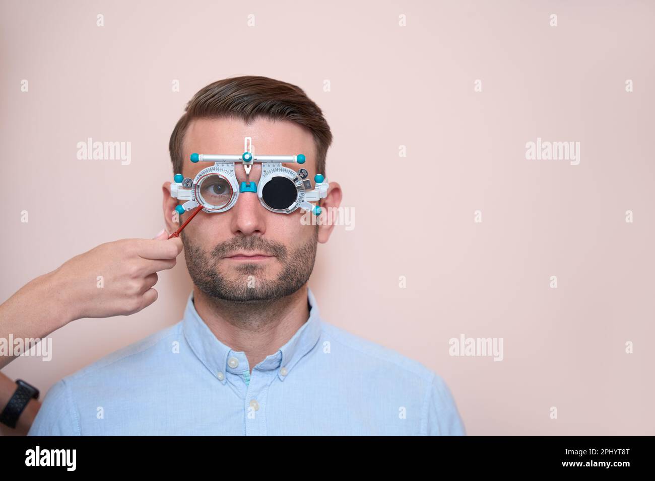 Adorable confident man is examining his eyesight in the modern optician ...