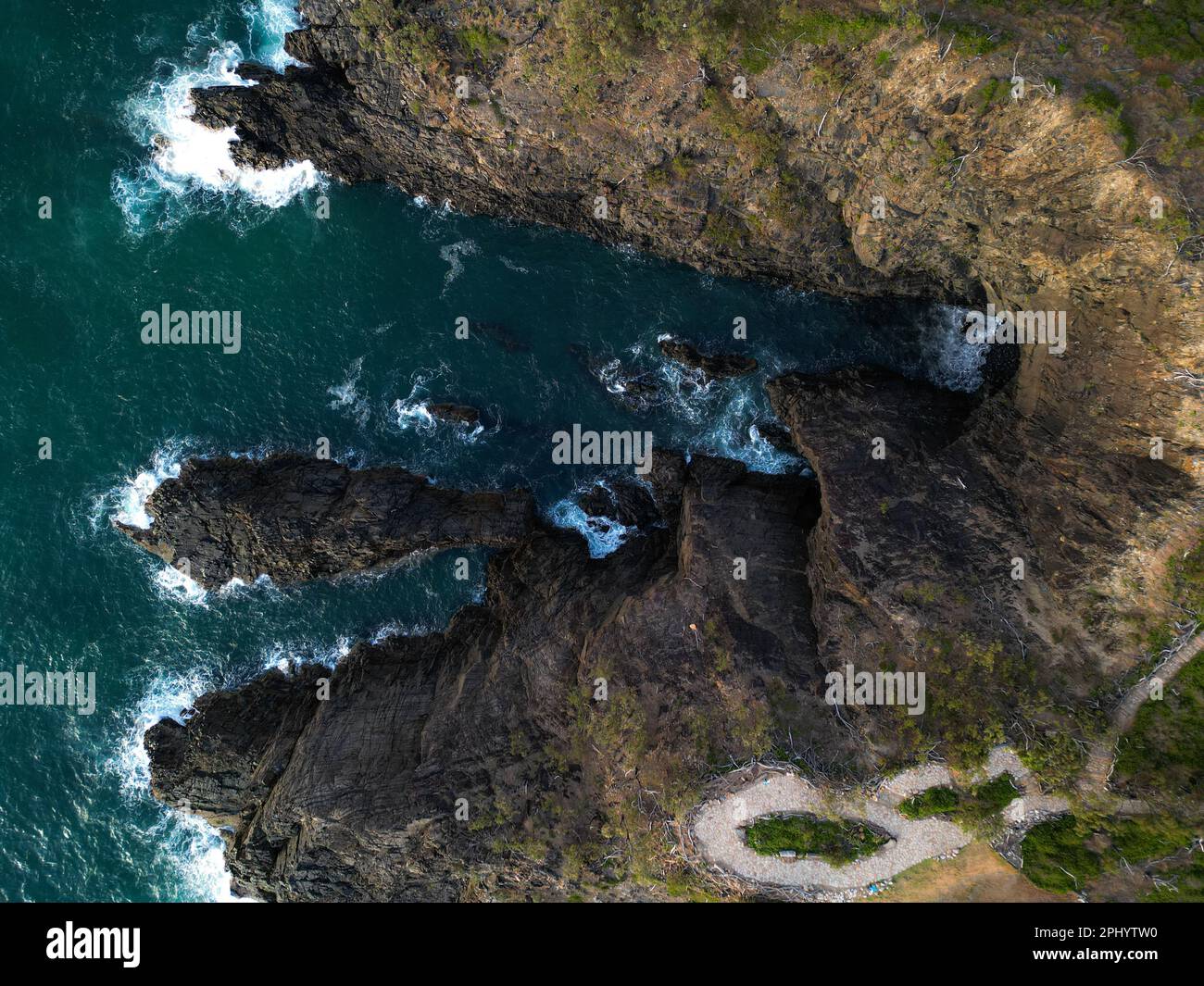 An aerial view of a scenic rocky coastline with beautiful blue ocean ...