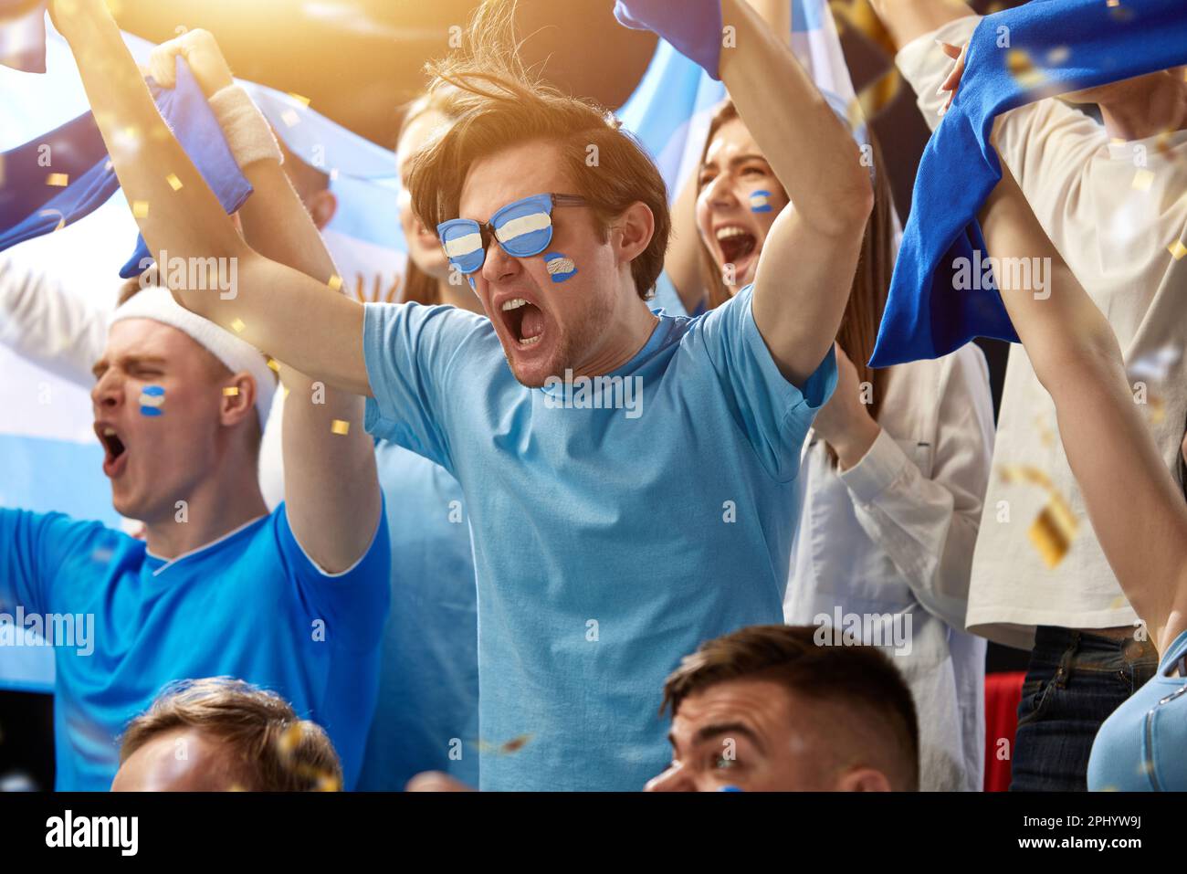 Sport fans with flags and paintings on faces, emotionally cheering up ...