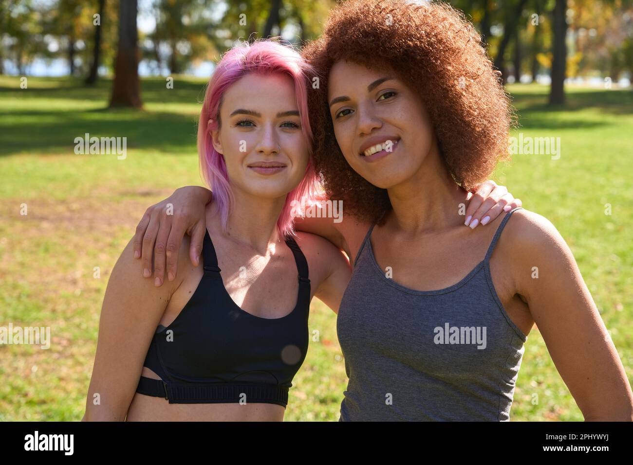 Pleased female athletes hugging each other outdoors Stock Photo - Alamy