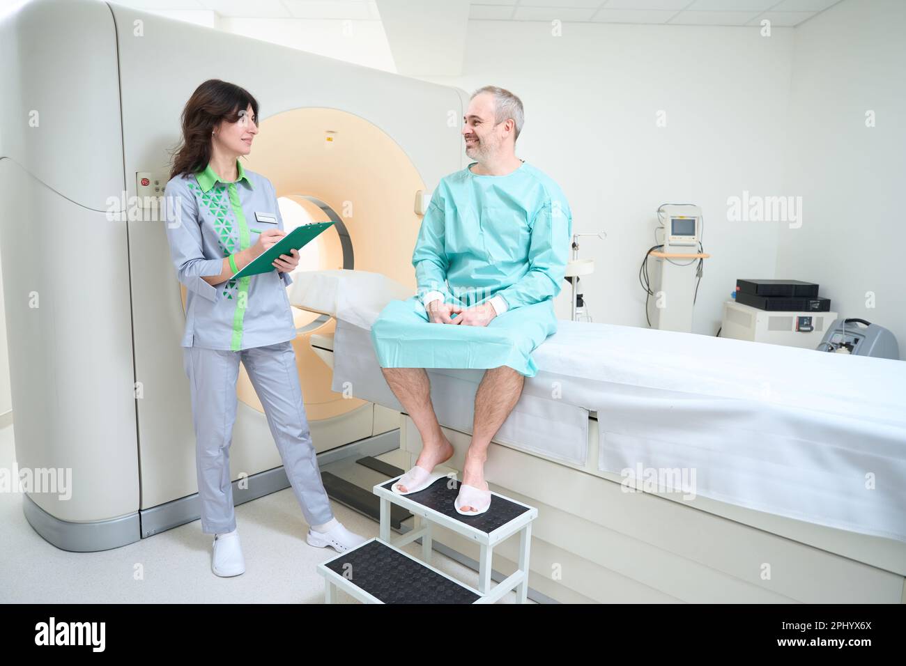 Happy male patient completing a questionnaire before MRI diagnostic ...