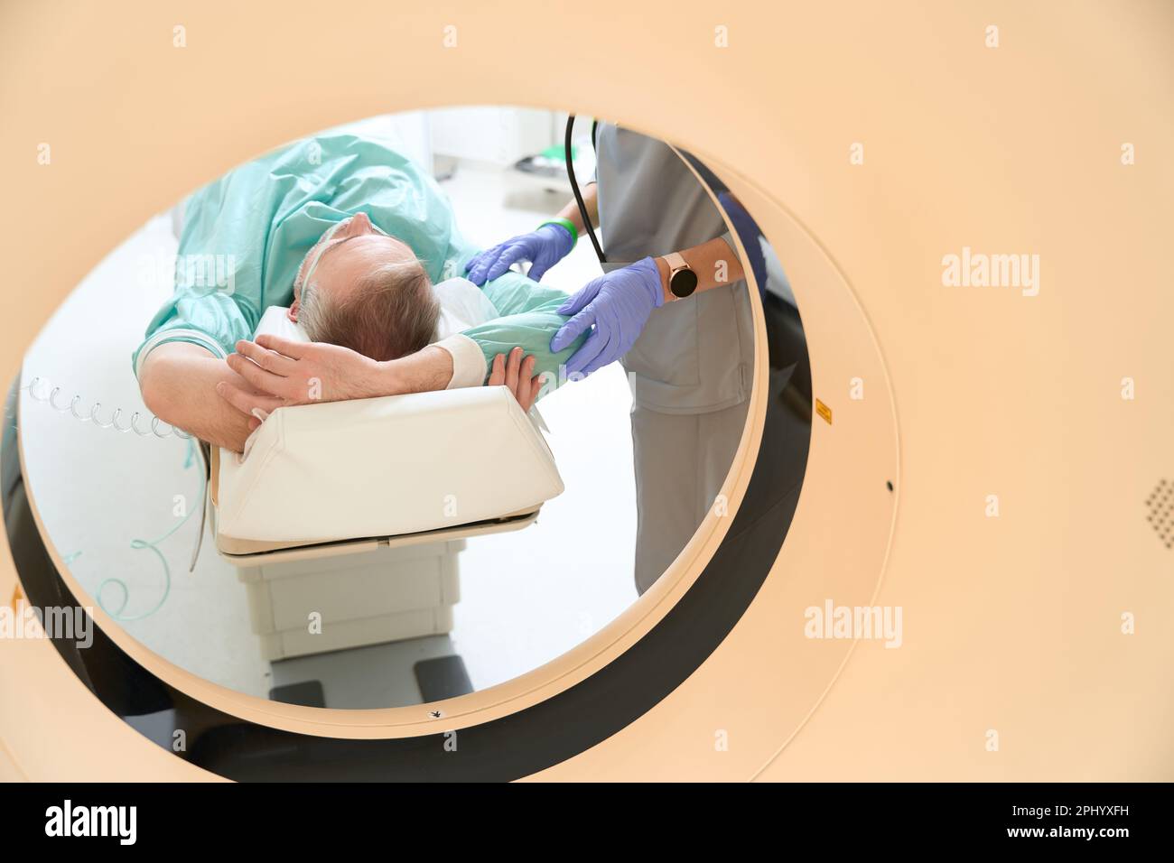 Man lying with hands up in chamber of MRI machine Stock Photo - Alamy