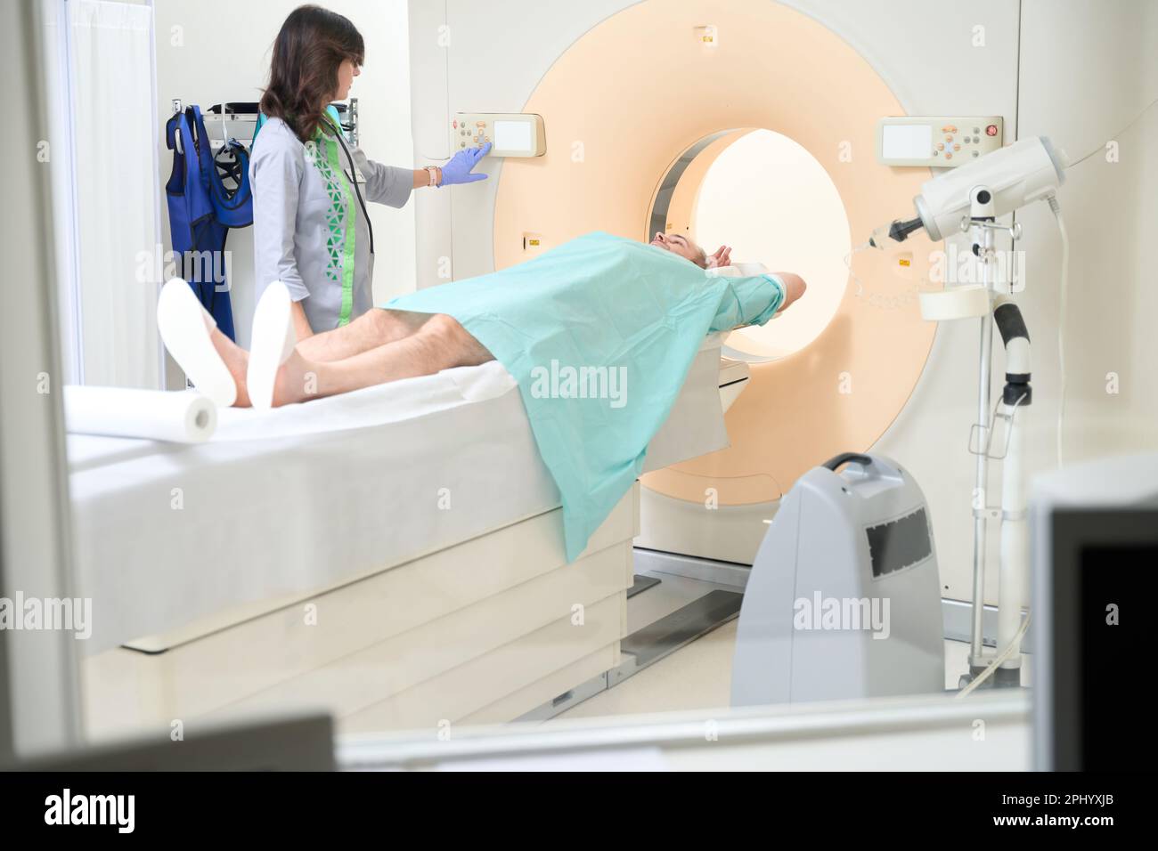 Doctor pressing button on remote control on MRI equipment Stock Photo ...