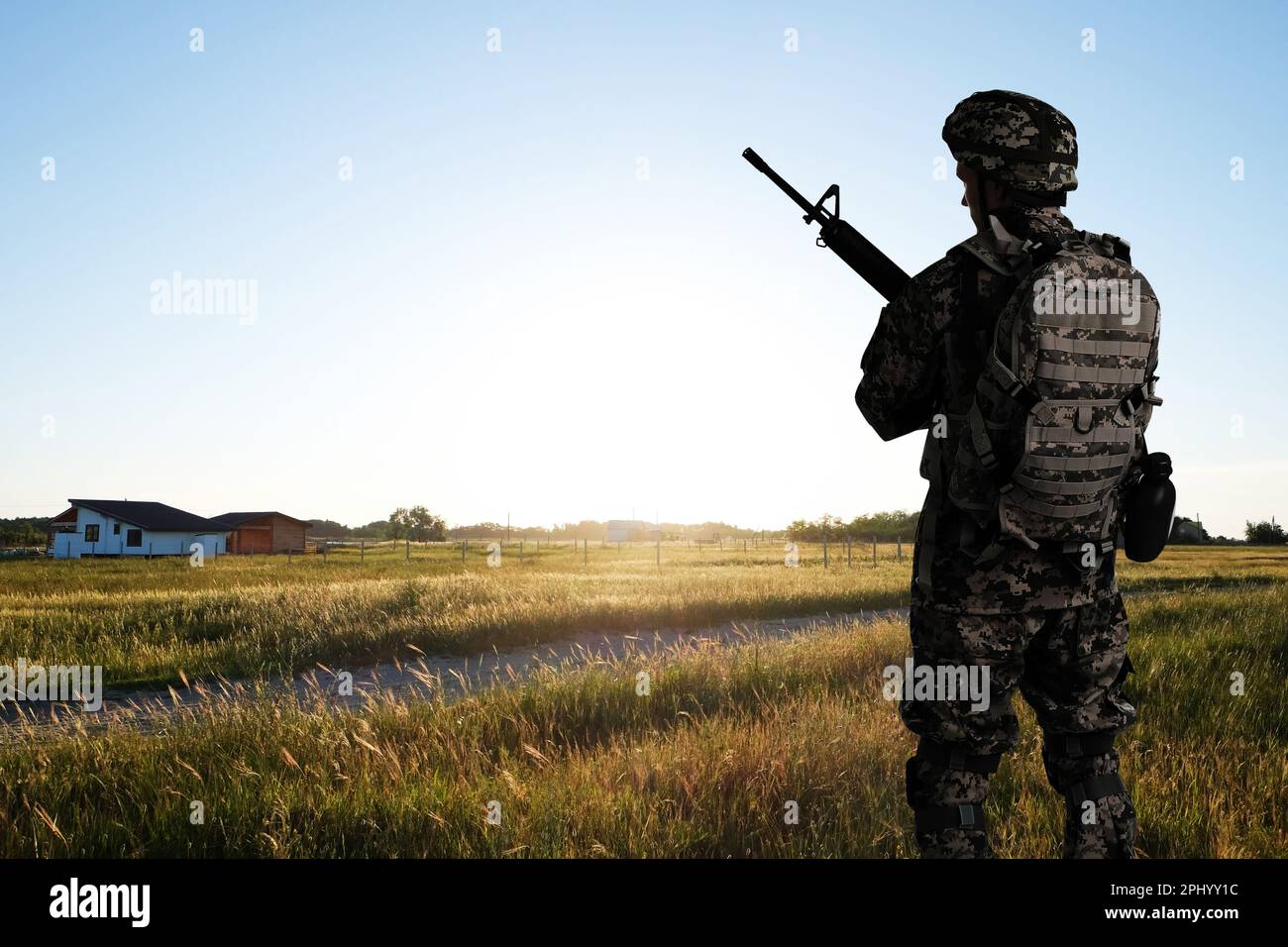 Soldier with machine gun outdoors, back view Stock Photo - Alamy