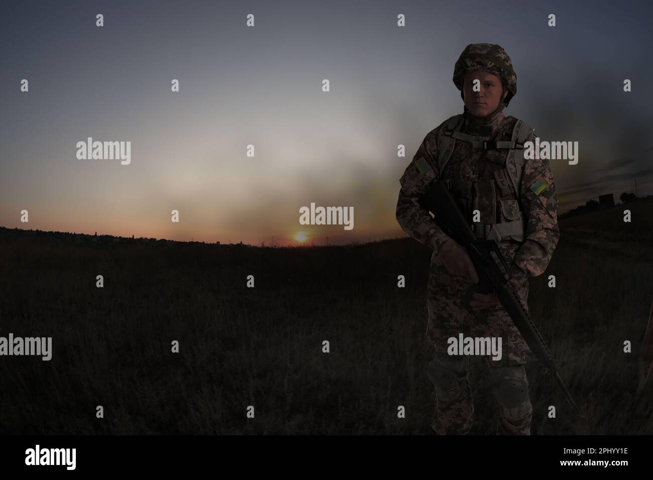 Ukrainian soldier with machine gun on battlefield at sunset Stock Photo ...