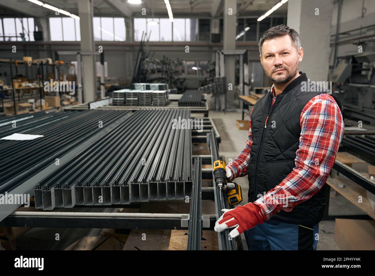Adult man standing next to metal structure Stock Photo - Alamy