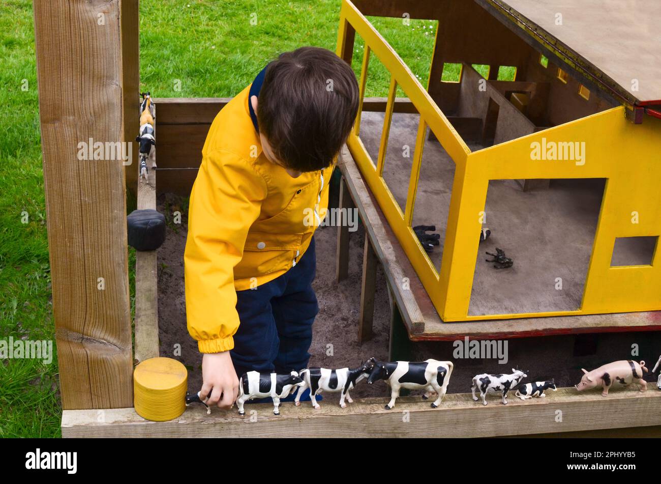 Little boy playing with toy cows in park Stock Photo - Alamy
