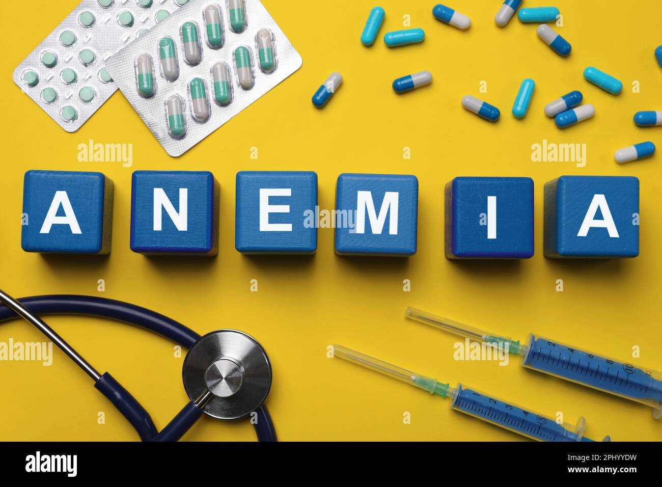 Word Anemia made with blue wooden cubes, pills, syringes and ...