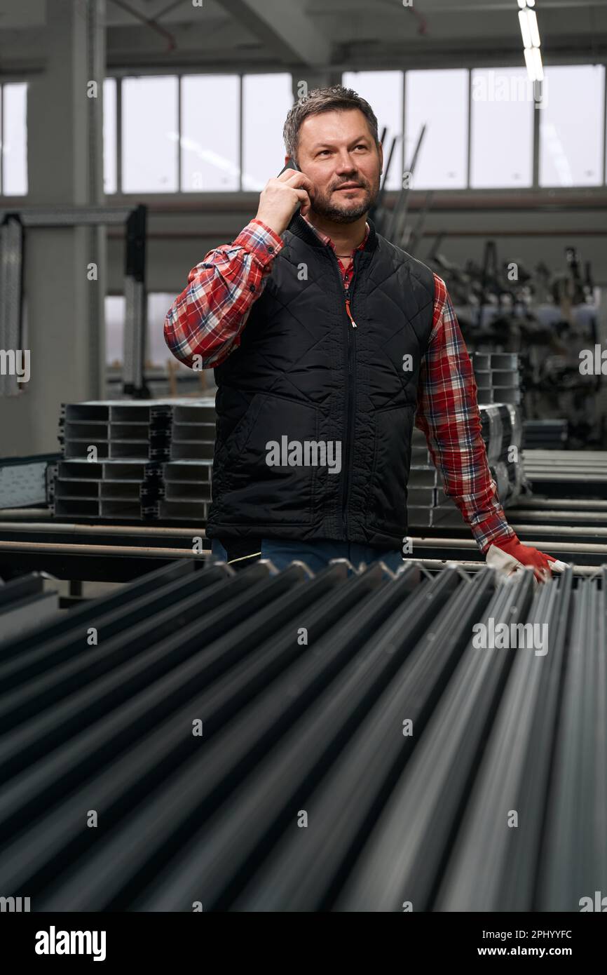 Adult man standing next to metal structure Stock Photo - Alamy