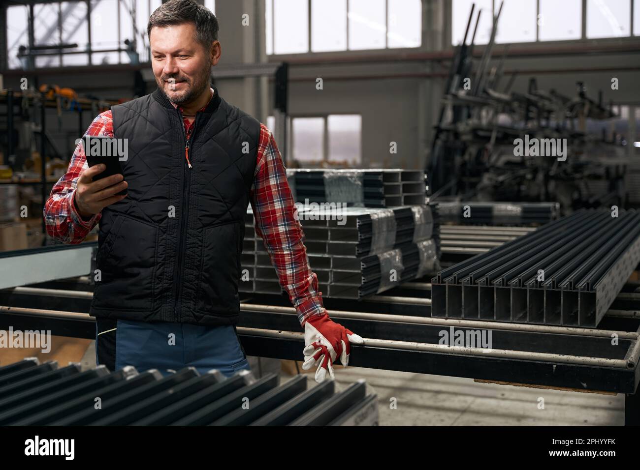 Happy male standing next to metal structure Stock Photo - Alamy