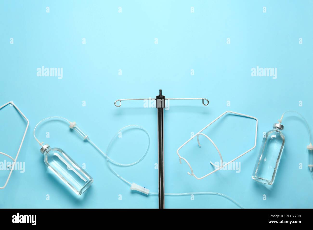 IV infusion set on light blue background, flat lay. Space for text ...