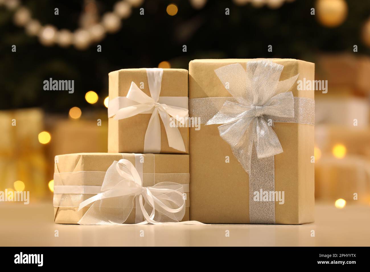 Beautifully wrapped gift boxes against blurred festive lights ...