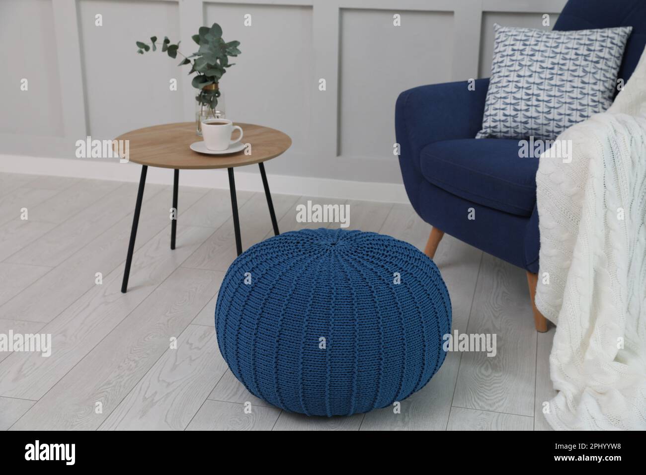 Stylish blue pouf near armchair in room. Interior design Stock Photo ...