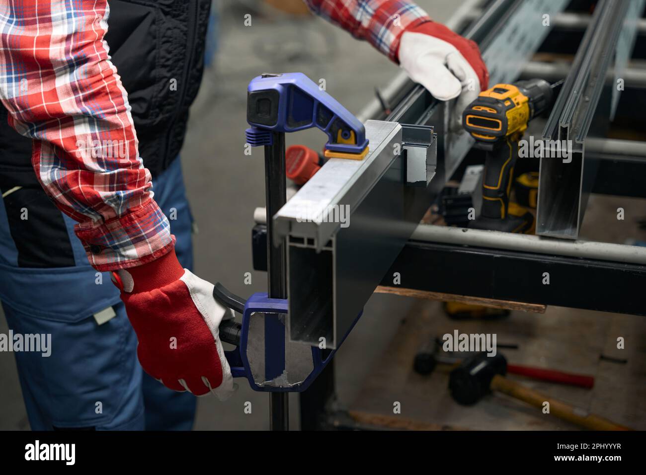 Man connecting two metal product together using tool Stock Photo - Alamy