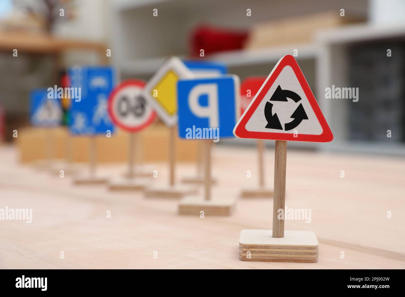 Different miniature road signs on wooden table, space for text ...