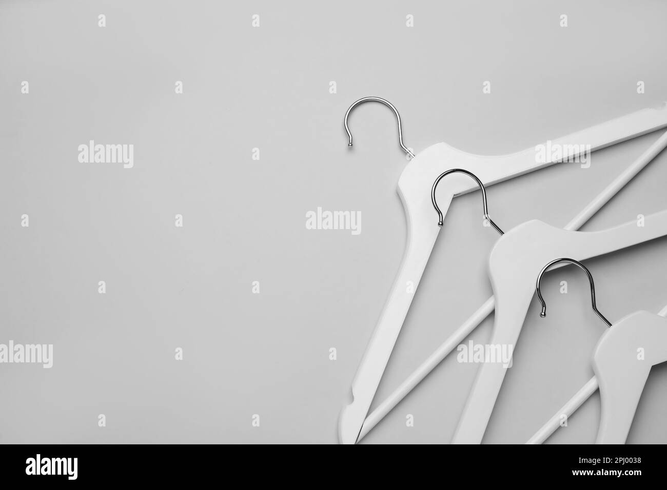 Empty clothes hangers on white background, flat lay. Space for text ...