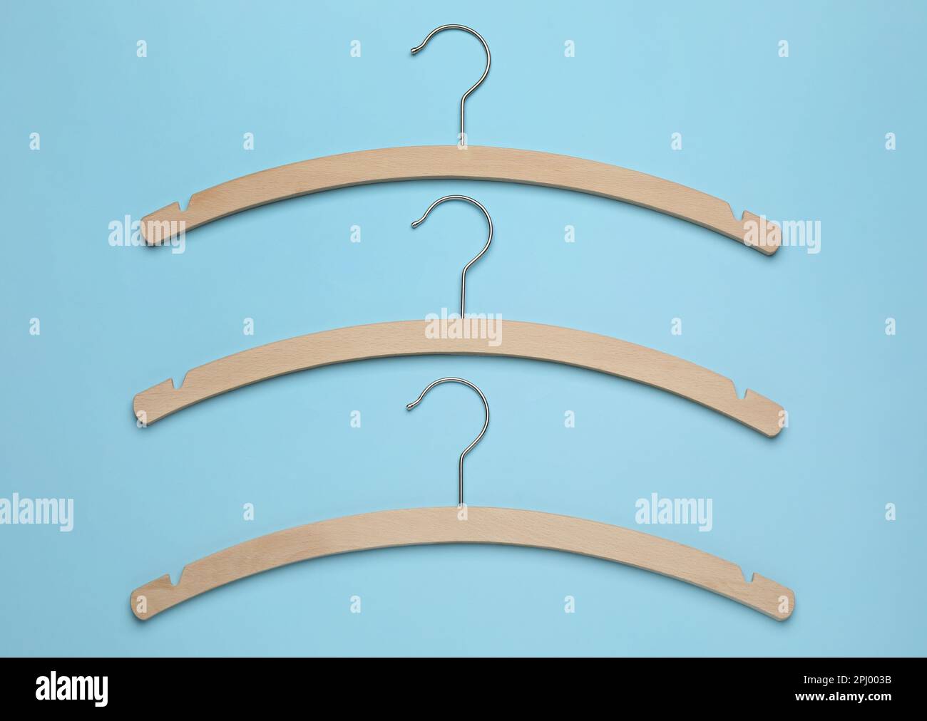 Empty hangers on light blue background, flat lay Stock Photo - Alamy