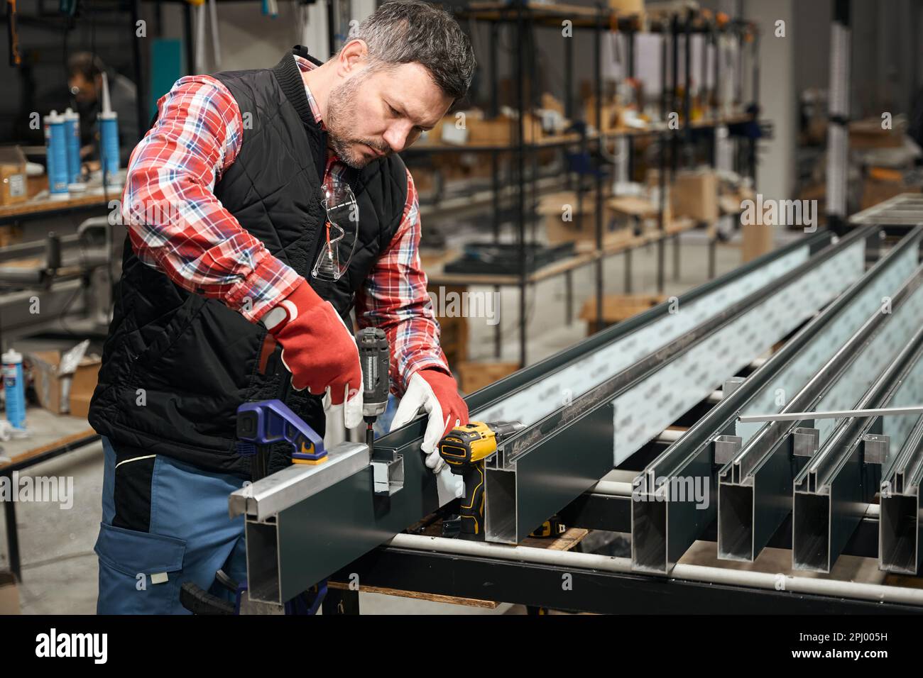 Adult male assembling metal structure in workshop Stock Photo - Alamy