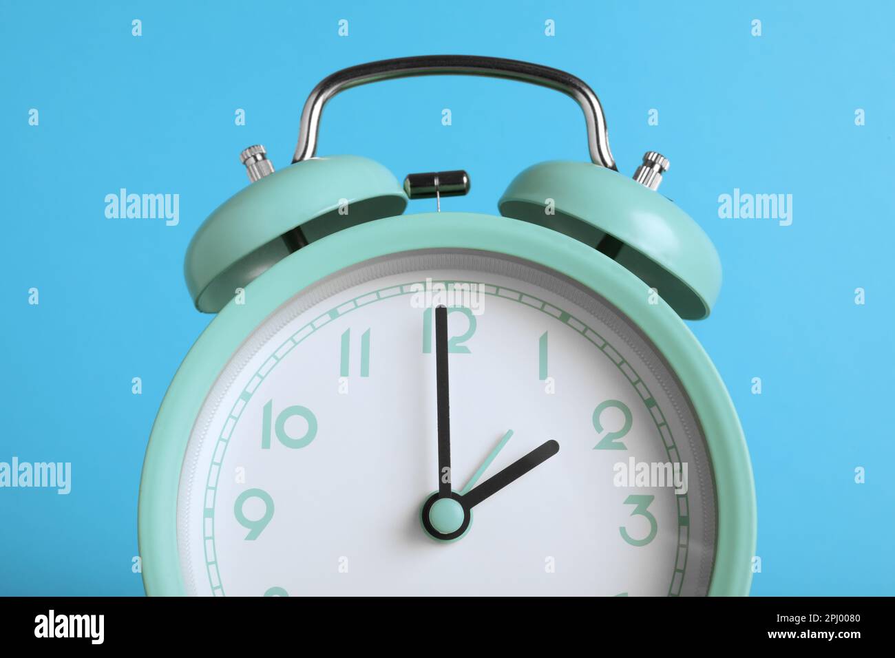 Turquoise alarm clock on light blue background, closeup Stock Photo - Alamy