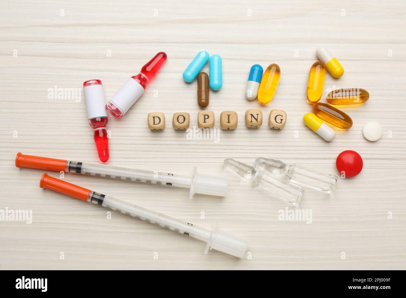 Flat lay composition with word Doping and drugs on white wooden table ...