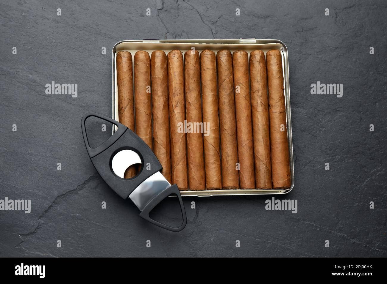 Cigars and guillotine cutter on black table, top view Stock Photo - Alamy