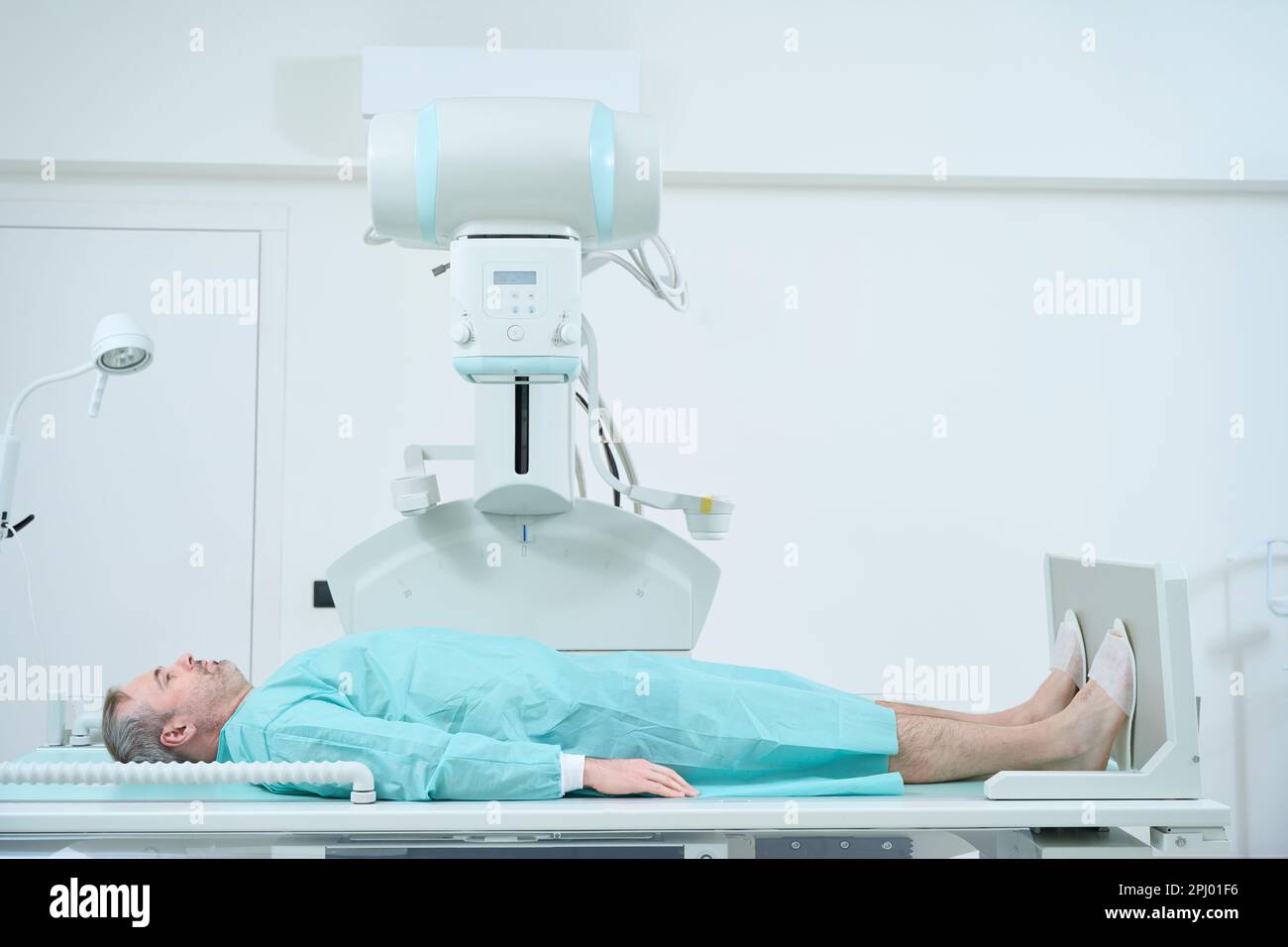 Male patient lying on x-ray table in hospital room in clinic Stock ...