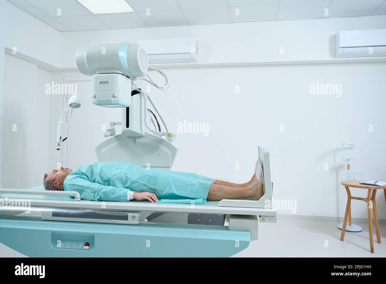 Man lying on bed waiting for X-Ray machine to scan for injury Stock ...