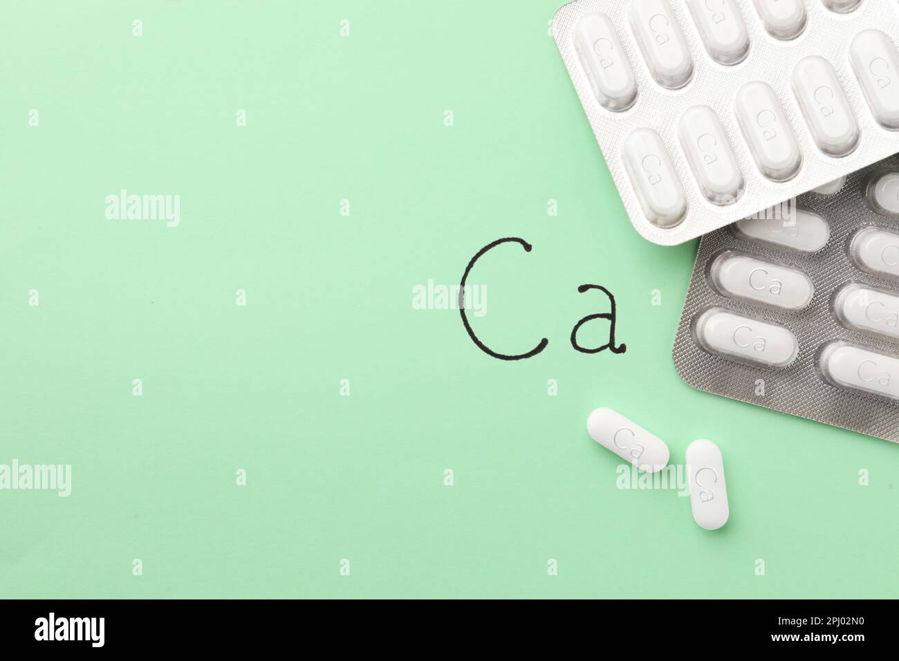 Blister packs with calcium supplement pills on light green background ...