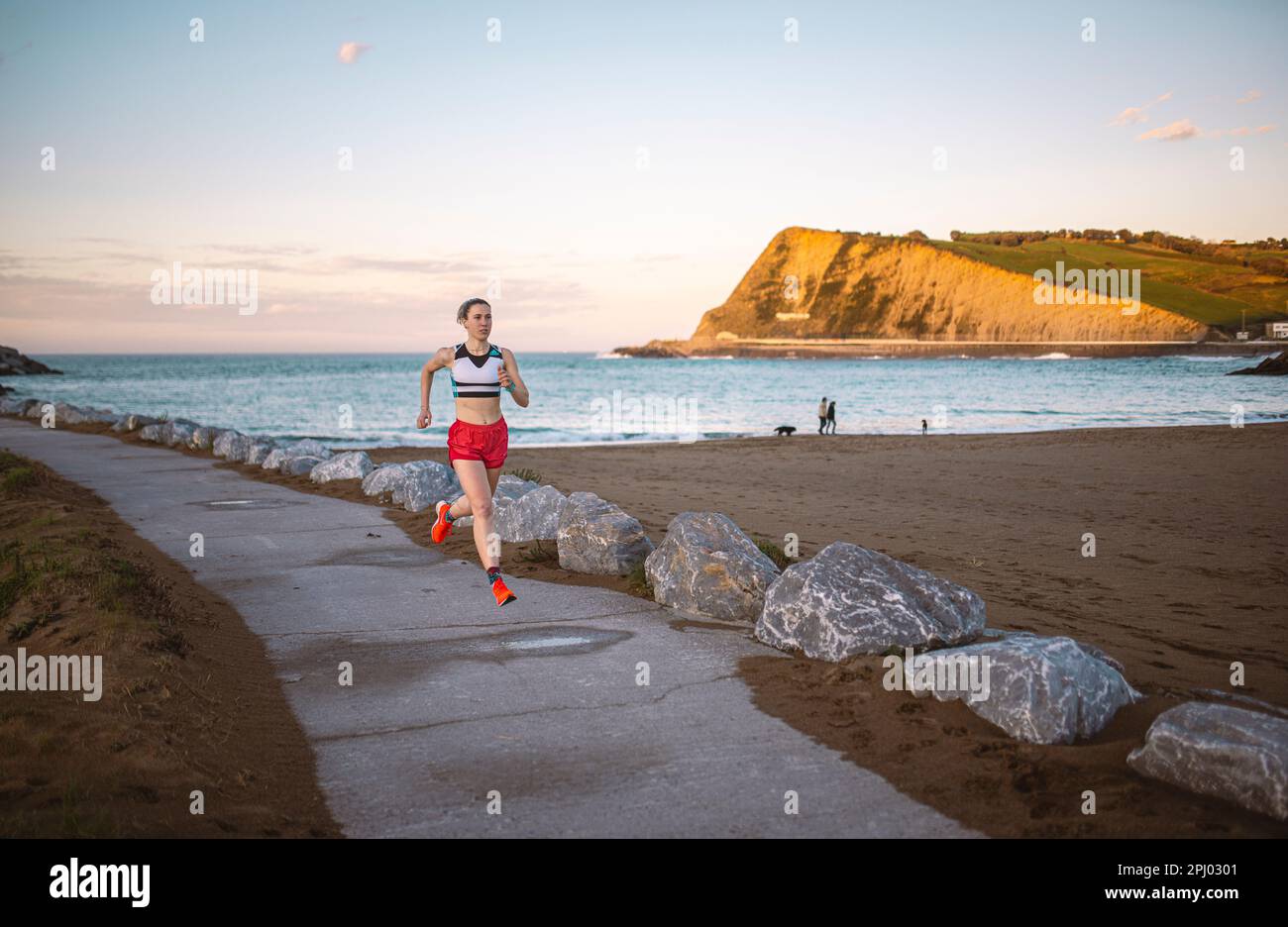 Woman running on a beautiful path with a sunset Stock Photo - Alamy