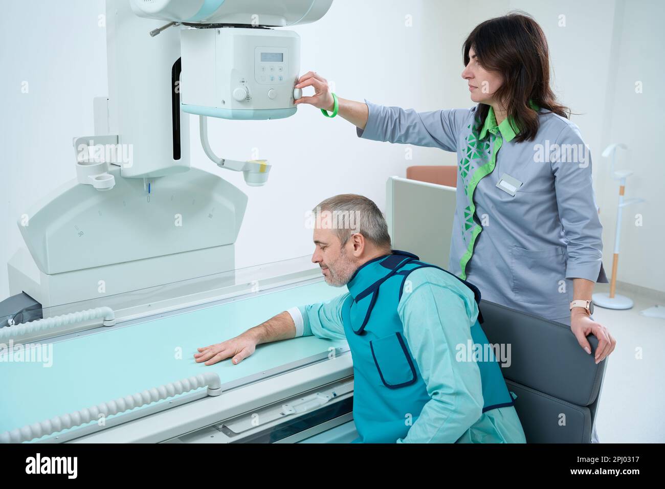 Female doctor preparing MRI scanner to making x-ray of hand at ...