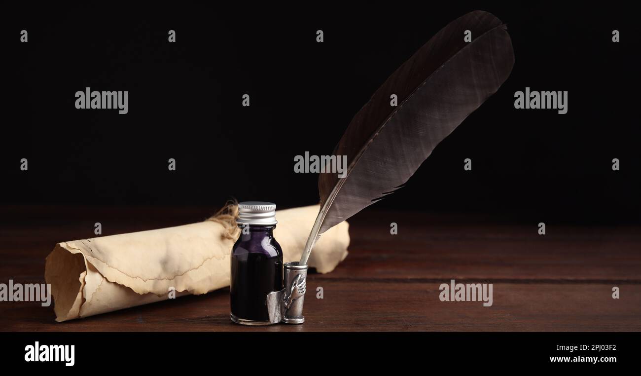 Quill, bottle of ink and parchment scroll on wooden table. Banner ...