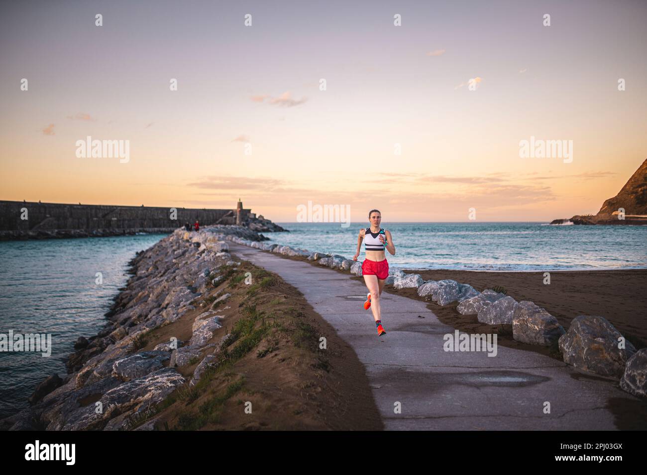 Woman running on a beautiful path with a sunset Stock Photo - Alamy