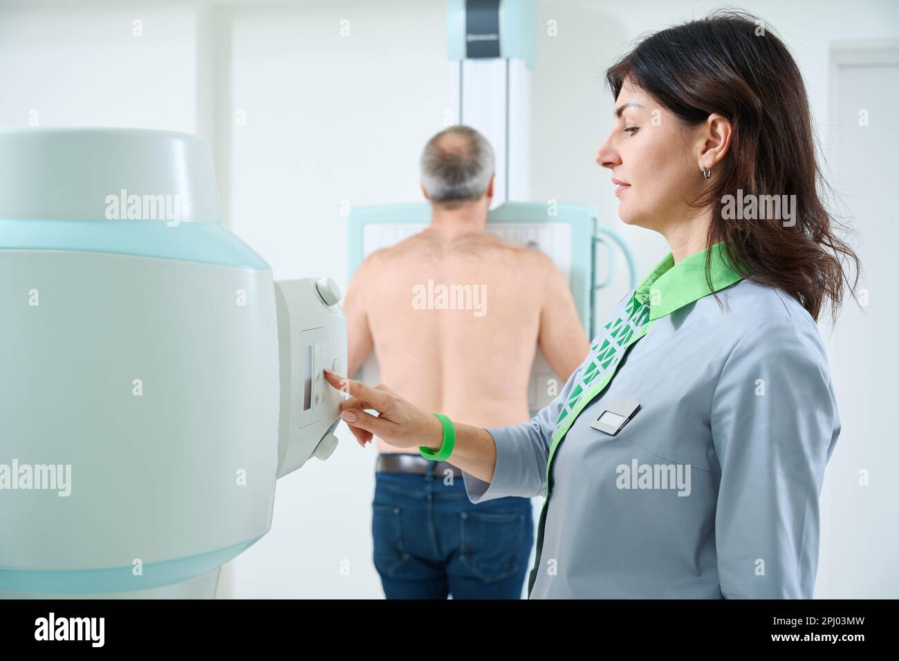 Doctor operating X-ray machine while standing near the patient Stock ...