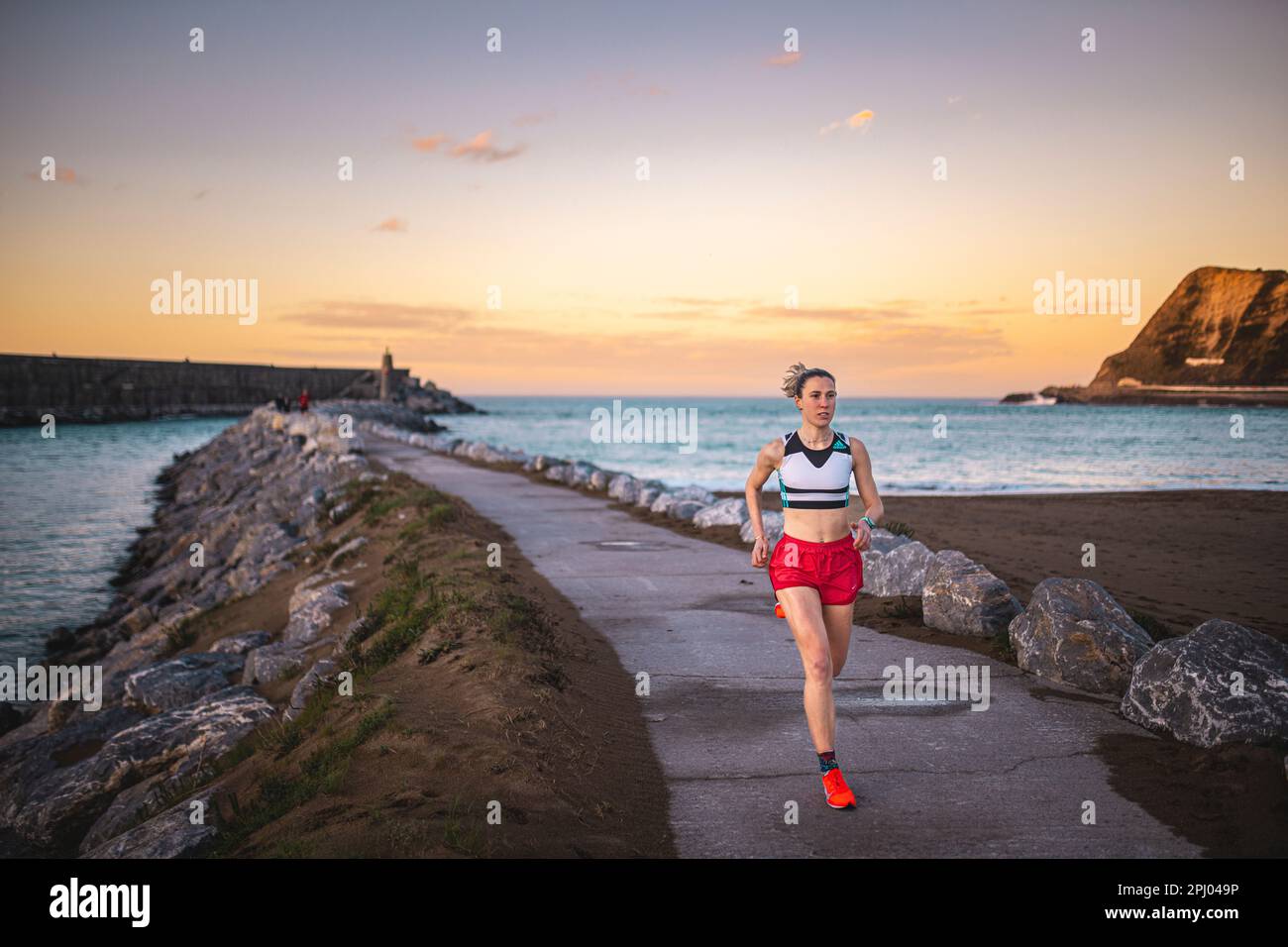 Woman running on a beautiful path with a sunset Stock Photo - Alamy